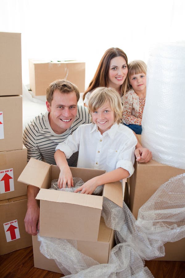Family Packing Boxes in New Home on Moving Day Stock Photo - Image of ...