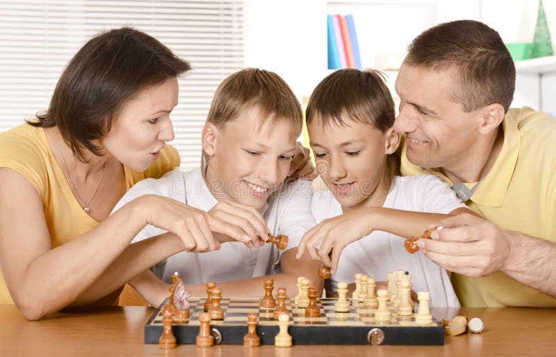 Happy family playing chess stock photo. Image of four - 61638072