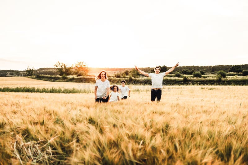 Happy Family Running through the Countryside. Family Having Fun Field ...