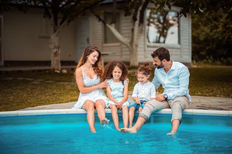 Family sitting by the pool stock photo. Image of outside - 214813190