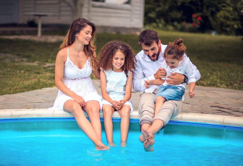 Family sitting by the pool stock photo. Image of outdoor - 214813204
