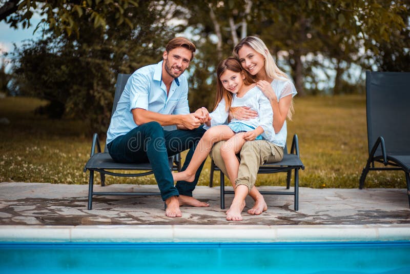 Family sitting by the pool stock image. Image of cheerful - 219520271
