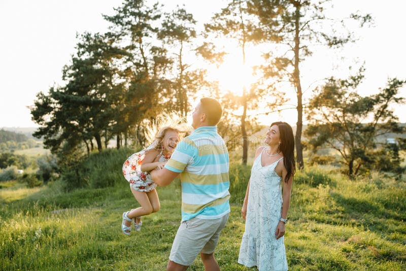 Happy Family of Three Persons Walking the Grass in the Park. Stock ...
