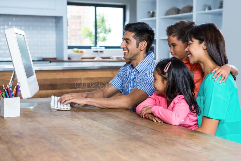 Happy Family Using Computer in the Kitchen Stock Photo - Image of ...