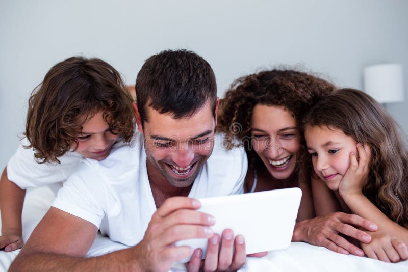 Happy Family Using Digital Tablet on Bed Stock Photo - Image of front ...