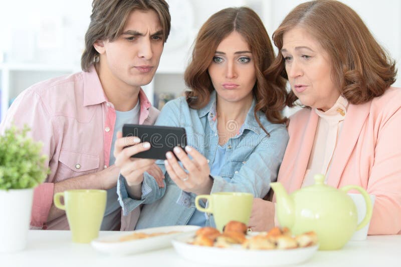 Happy Family Using Mobile Phone Together Stock Photo - Image of table ...