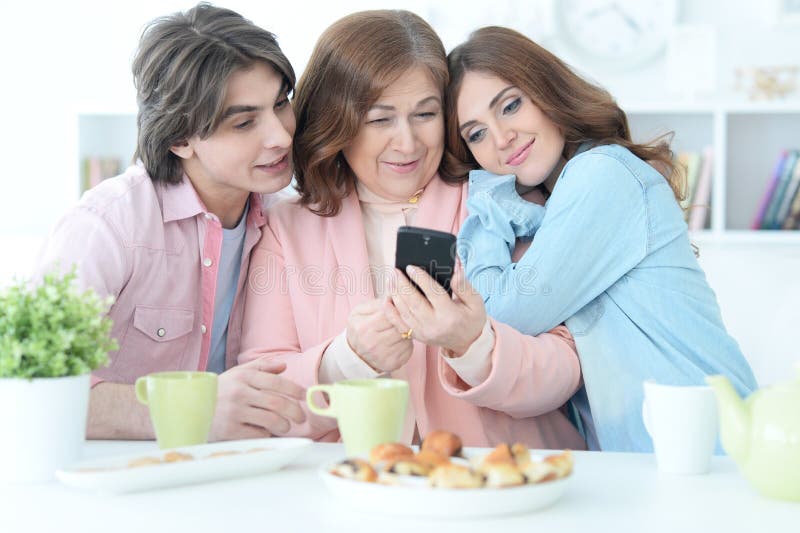 Happy Family Using Mobile Phone Together Stock Photo - Image of ...