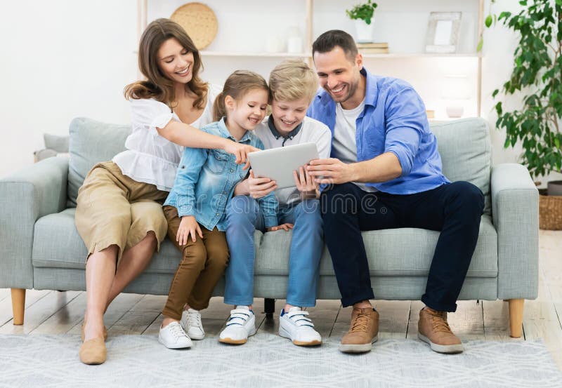 Happy Family Using Tablet Computer Together on Couch at Home Stock ...