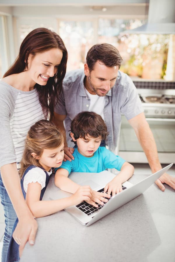 Happy Family Working on Laptop at Table Stock Image - Image of male ...