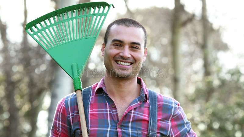 Happy farmer holding rake stock video. Video of outdoor - 62991475