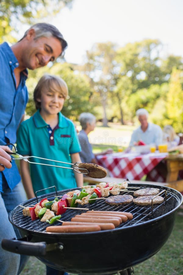 Happy Father Doing Barbecue with His Son Stock Image - Image of ...