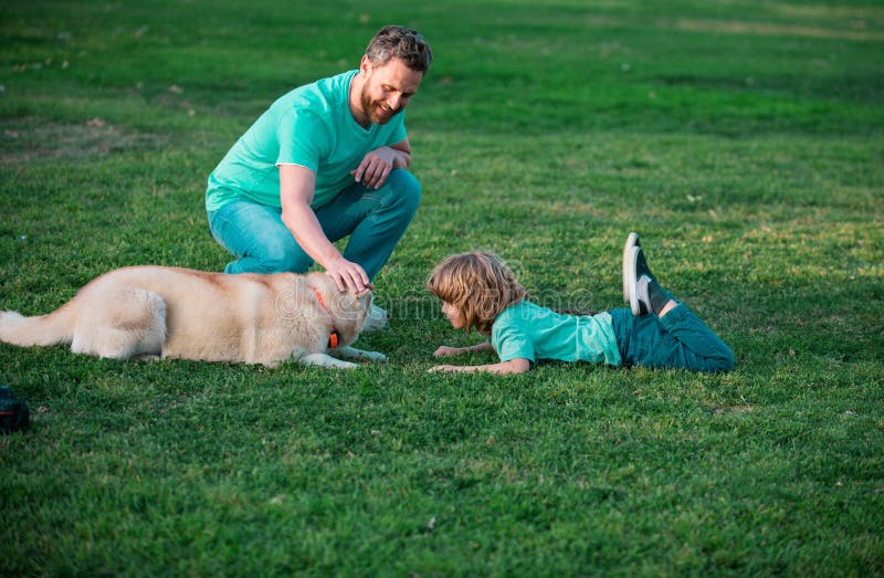 Happy Father and His Son Playing with Dog in Summer Park. Stock Photo ...
