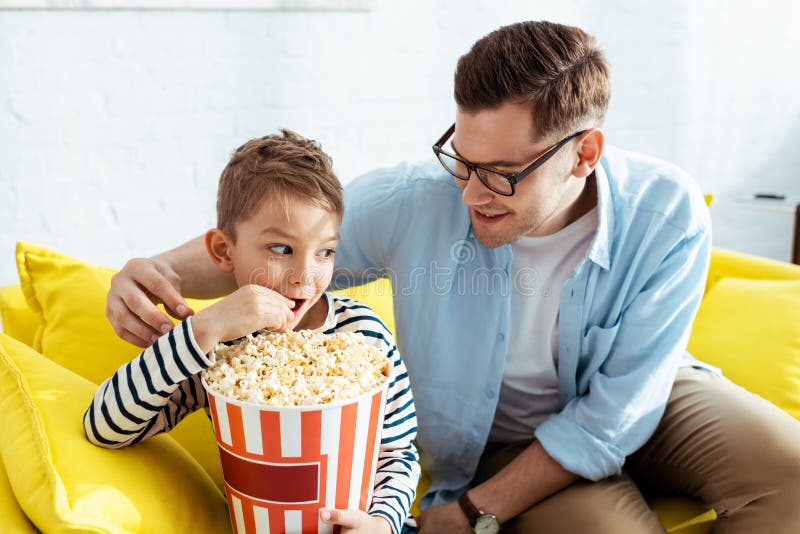 Happy Father Looking at Son Eating Stock Image - Image of eyeglasses ...
