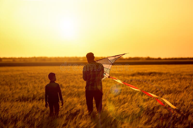 Happy Father and Son Flying Kite in the Field at Sunset Stock Photo ...