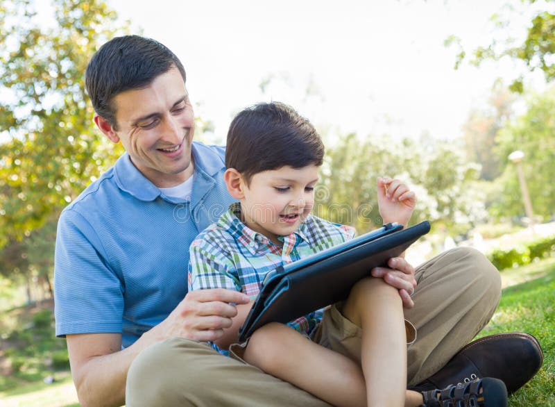 Helpful Father and Son Playing on a Computer Tablet Outside. Stock ...