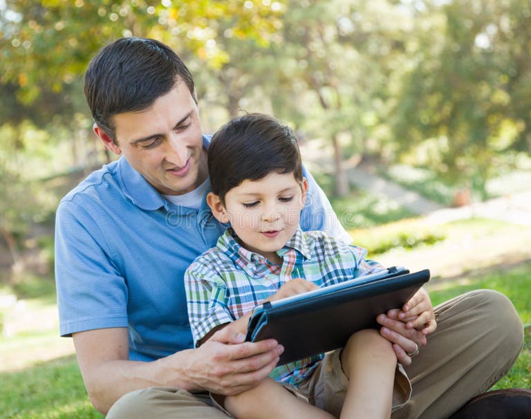 Happy Father and Son Playing on a Computer Tablet Outside. Stock Image ...