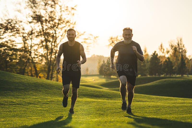 The Happy Father and a Son Running on the Park Grass. Stock Photo ...