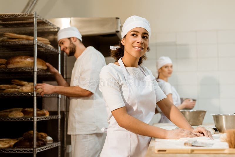 Happy female baker working stock photo. Image of industrial - 129239368