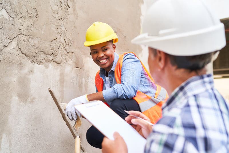 Happy Female Bricklayer with Trowel Crouching Near Senior Builder at ...