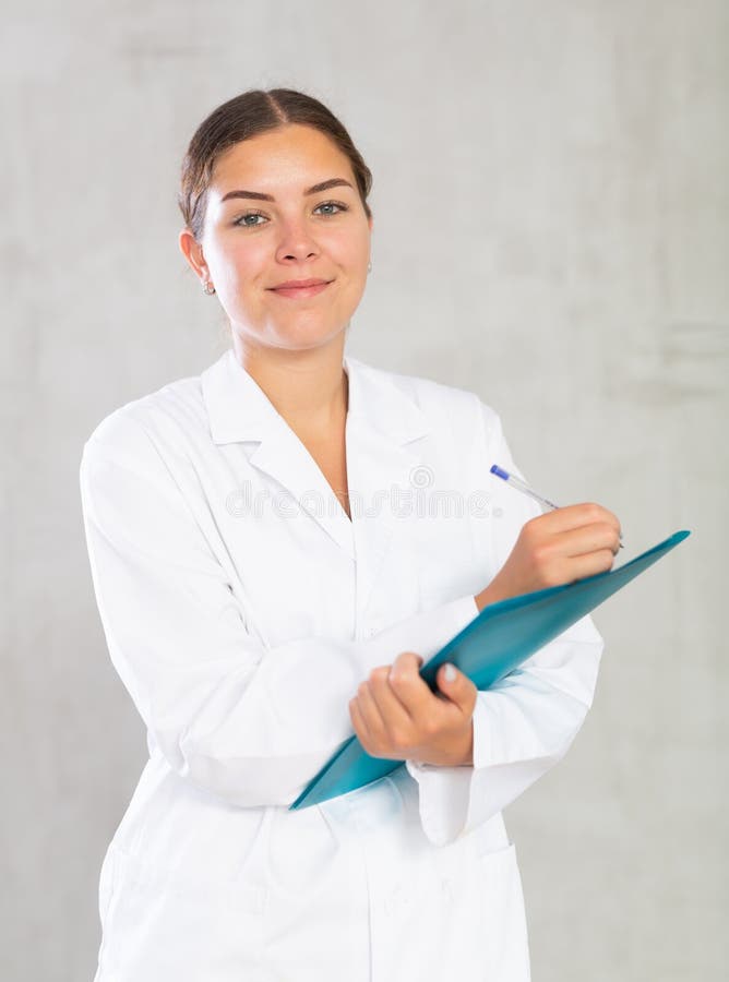 Happy Female Doctor Standing and Making Notes in File Stock Image ...