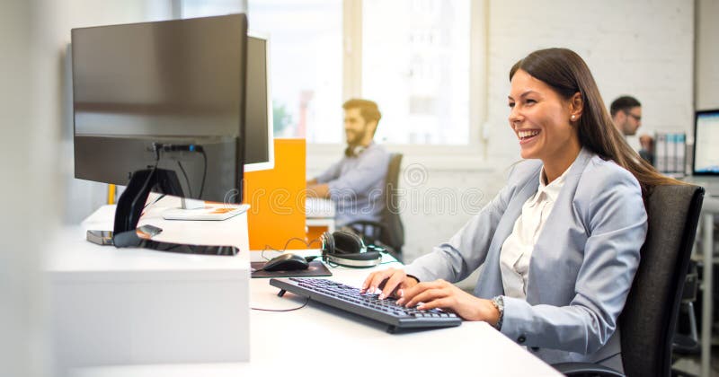 Happy Female Employee in Suit Using Computer at Office. Stock Image ...
