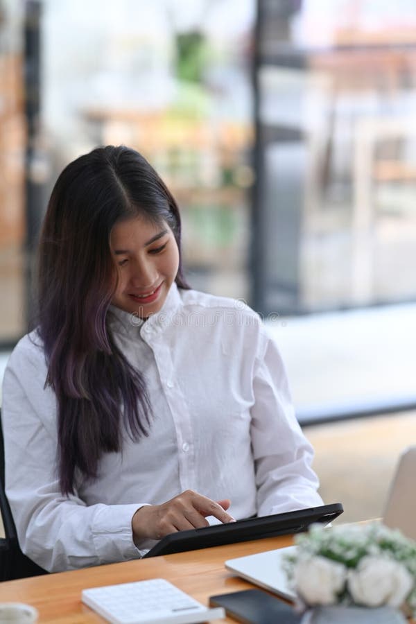 Happy Office Worker Sitting at Her Office Desk and Using Digital Tablet ...