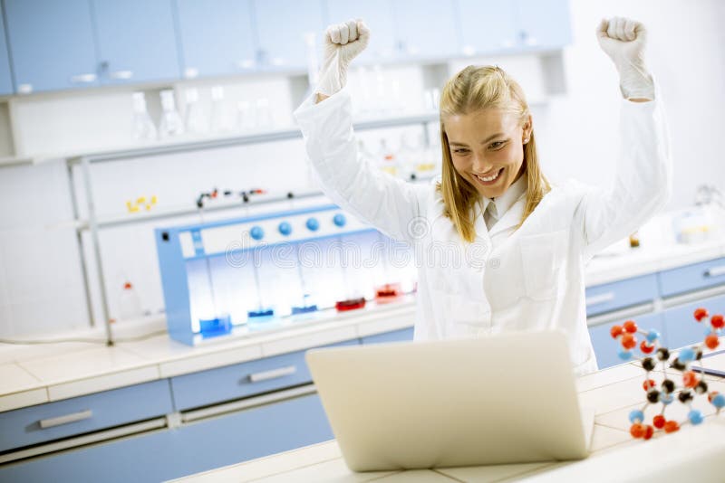 Happy Female Researcher in White Lab Coat Using Laptop while Working in ...