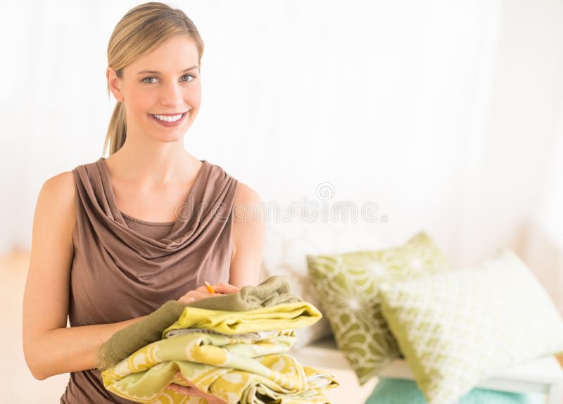 Happy Female Store Owner Holding Sheets in Bedding Store Stock Photo ...