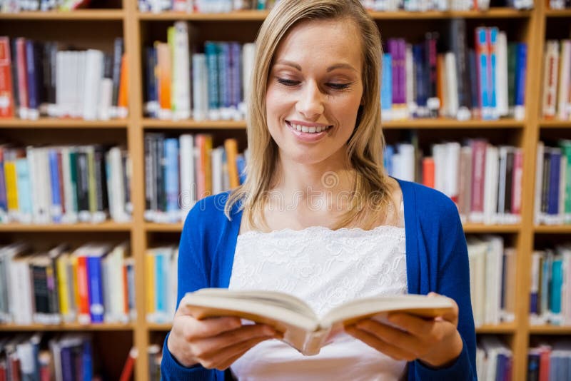 Happy Female Student Reading a Book in the Library Stock Image - Image ...