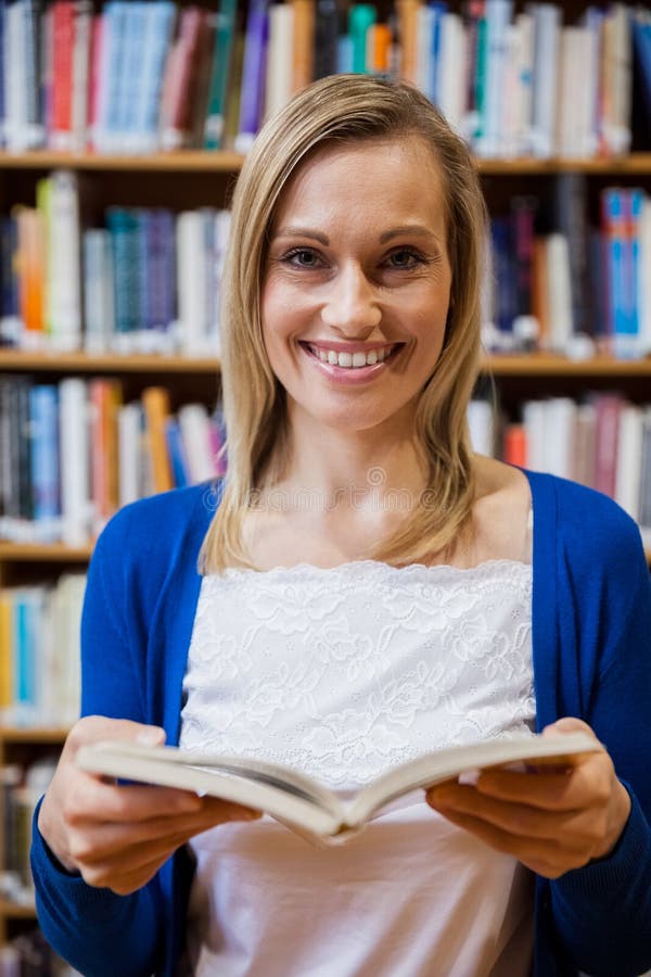 Happy Female Student Reading a Book in the Library Stock Photo - Image ...