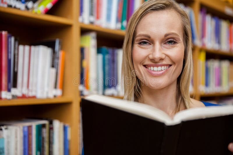 Happy Female Student Reading a Book in the Library Stock Image - Image ...