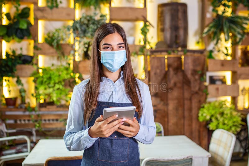 Happy Female Waitress Using Digital Tablet while Wearing Protective ...