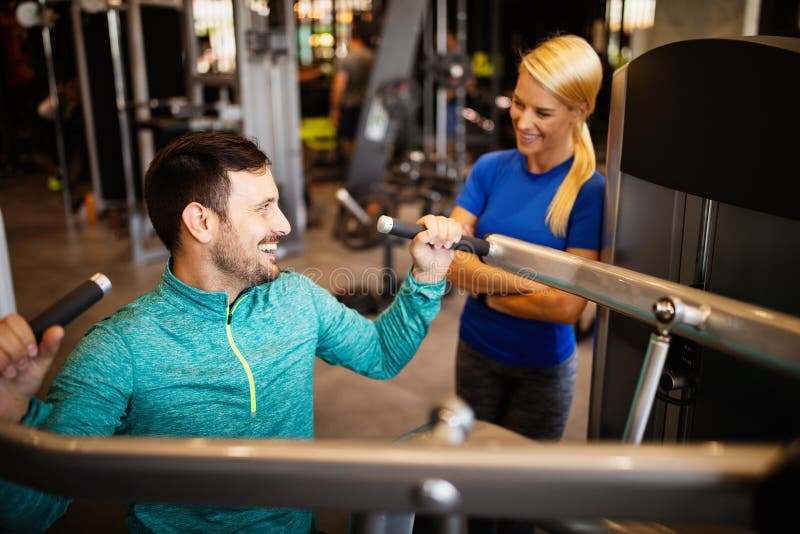 Happy Fit Man with His Personal Trainer Doing Exercise at the Gym Stock ...