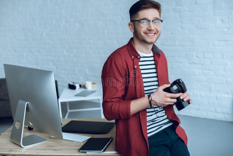 Happy Freelancer Holding Camera by Working Table Stock Photo - Image of ...