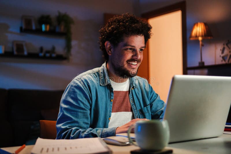 Happy Freelancer Man Working at Home with a Laptop on a Desk at Late ...