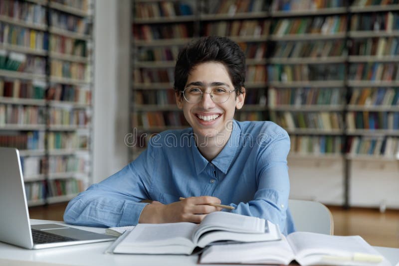 Happy Fresh Student Guy in Glasses Writing Essay in Library Stock Image ...