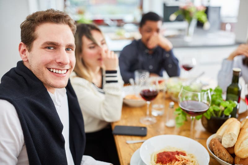 Happy Friends Eating Pasta Together at Table in Kitchen Stock Image ...