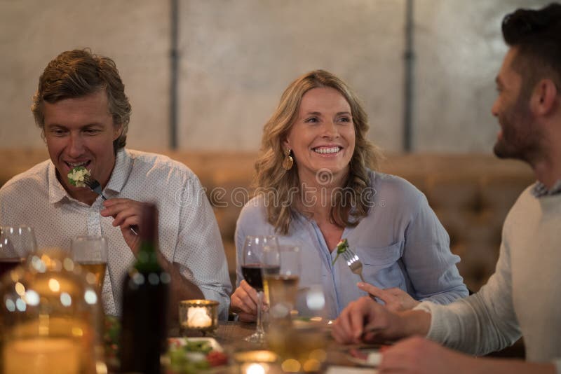 Friends Interacting while Dining in Restaurant Stock Photo - Image of ...
