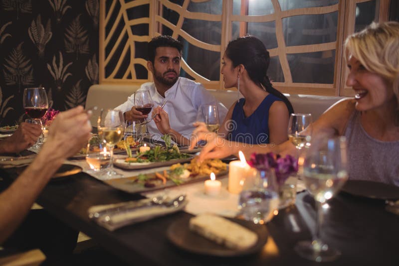 Happy Friends Interacting with Each Other while Having Dinner Stock ...