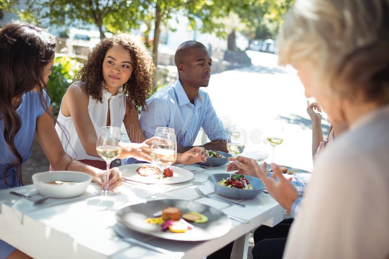 Happy Friends Interacting with Each Other while Having Meal Stock Photo ...