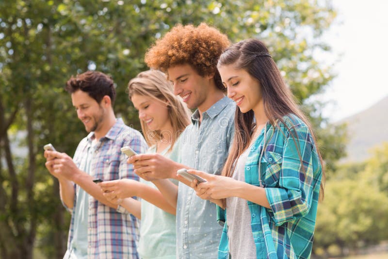Happy Friends in the Park Using Their Phones Stock Image - Image of ...