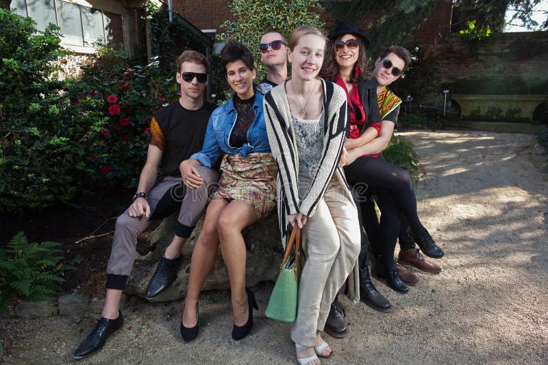 Happy Friends on Rock in Park Stock Photo - Image of casual, diversity ...