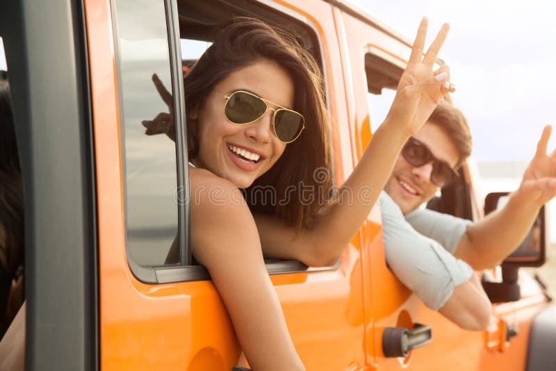 Happy Friends Sitting in a Car and Showing Peace Gesture Stock Photo ...