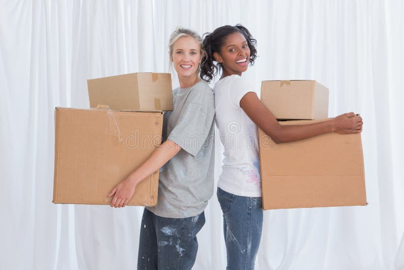 Happy Friends Standing Back To Back Holding Moving Boxes Stock Photo ...