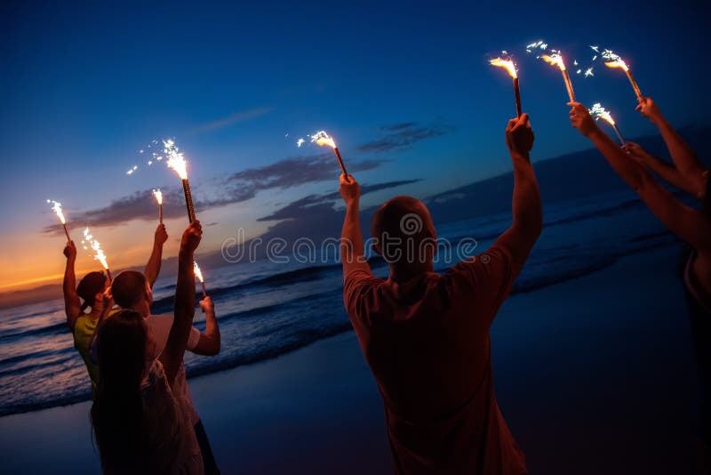 Happy Friends at Sunset Beach Party with Fireworks Stock Photo - Image ...