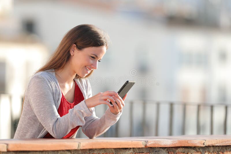 Happy Girl Using a Mobile Phone in a Balcony Stock Photo - Image of ...