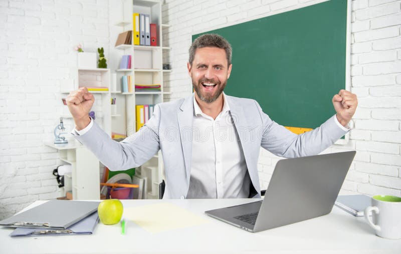 Happy Glad School Teacher in Classroom with Computer at Blackboard ...