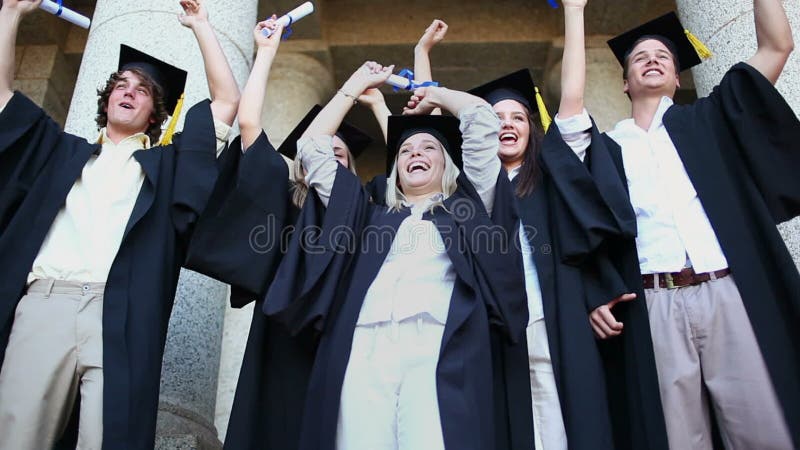 Happy Graduated Man in a Black Gown Showing His Diploma To the Camera ...