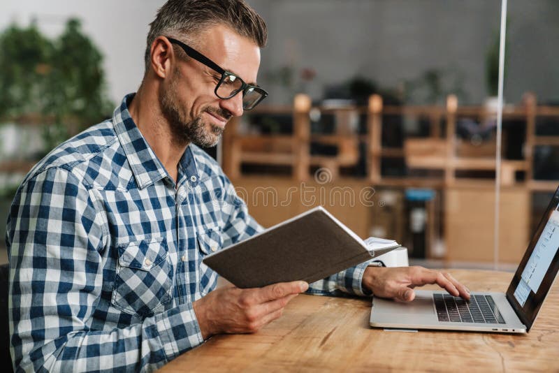 Happy Grey Man in Eyeglasses Reading while Working with Laptop Stock ...