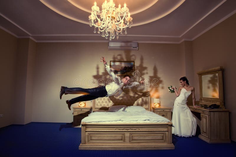 Happy groom flying on bed stock photo. Image of happiness - 24556638